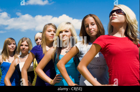 seven teenage girls standing in a semicircle putting their hands on top ...