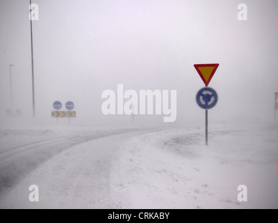 A road sign covered in snow warning car drivers of hazardous driving ...