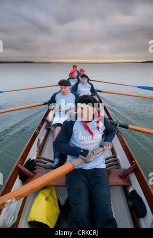 Rowing crew aboard a skiff in Langstone Harbour, near Hayling Island ...