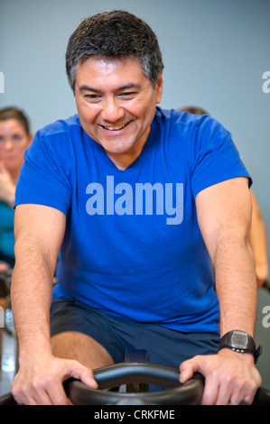 Smiling man working out at spinning class in bright gym Stock Photo - Alamy