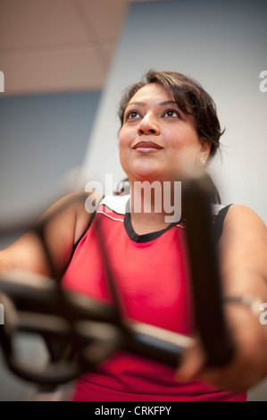 Woman in gym spinning on fitness bike Stock Photo - Alamy