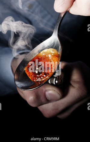 man cooking up some drugs on a spoon with a lighter Stock Photo ...