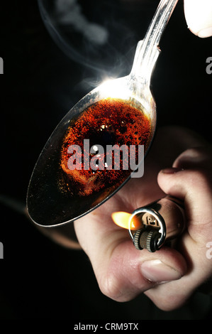man cooking up some drugs on a spoon with a lighter Stock Photo - Alamy