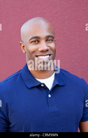 Portrait of young happy bald African businessman smiling with arms ...
