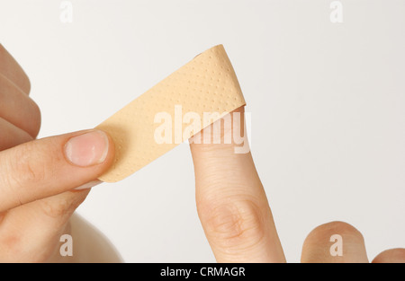 A person putting a plaster on their finger Stock Photo: 1590138 - Alamy