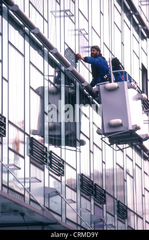 Window cleaners in a gondola (Building Maintenance unit BMU) on ...