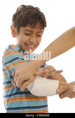 A young boy with a bandaged elbow, grimacing in pain Stock Photo - Alamy