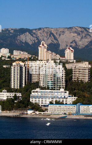 Ukraine, Yalta. Black Sea view of the port of Yalta. Crowded beach with ...