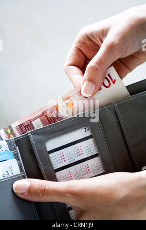 Hands taking out money from wallet. Full wallet of American dollars ...