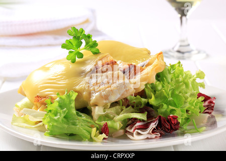 Cheese topped fish fillets served with French fries Stock Photo - Alamy