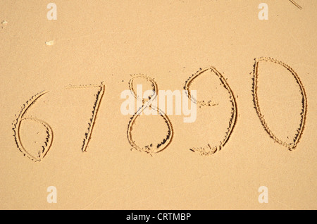 handwritten numbers on sand background Stock Photo - Alamy