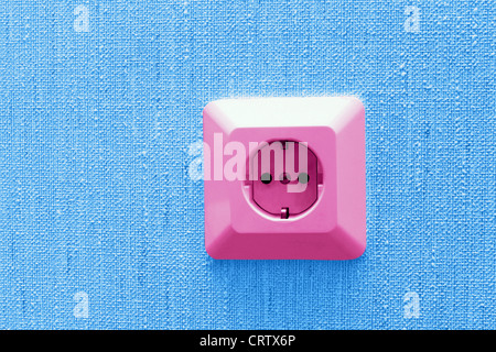 Pink electric socket on blue wall, abstract background Stock Photo - Alamy