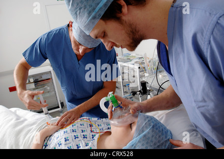 An anaesthetist administering medical gases to induce anaesthesia in a ...