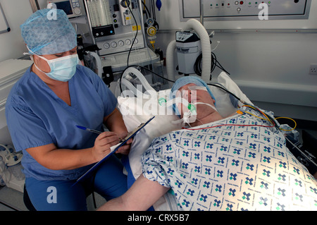 With his eyes taped, a male patient is being watched over by an ...