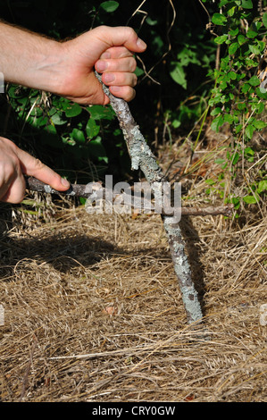 Wild man starting a fire in the snow Stock Photo - Alamy