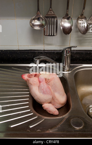 Raw Chicken under cold water tap in Kitchen Sink Stock Photo - Alamy