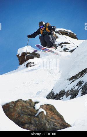 Skier jumping off snowy slope Stock Photo - Alamy