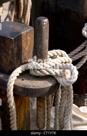 Old sailing ship rigging with belaying pins and ropes, shallow depth of ...