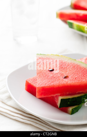 Plate with slices of watermelon and napkin on white background Stock ...