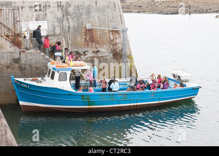 Seahouses Harbour with school children on a boat after a trip to the ...