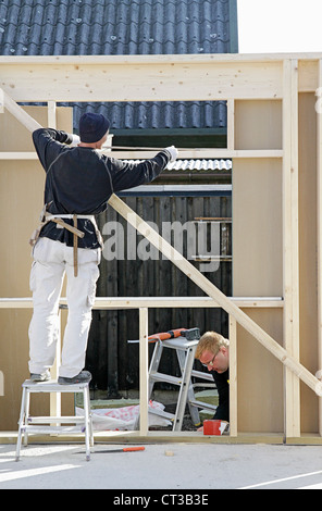 Two builders working on a house having a discussion with the ...