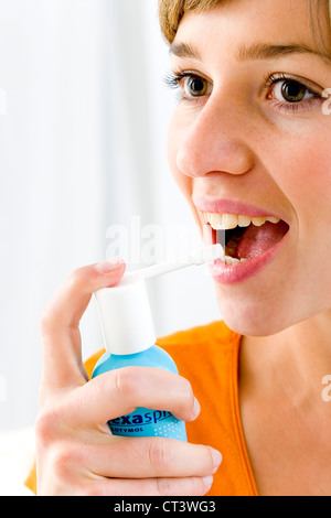 WOMAN USING SPRAY IN MOUTH Stock Photo - Alamy