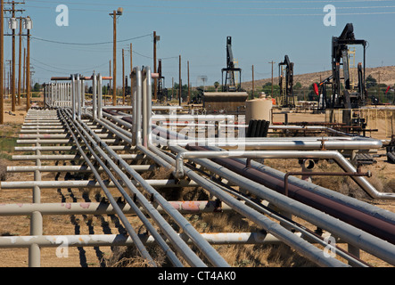 An expansion loop in a natural gas pipeline frames an oil well Stock ...