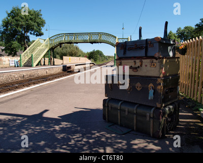 Old fashioned travel trunks on a luggage carrier at Washford Station ...