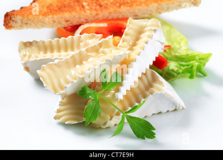 Toasted bread and wedges of white rind cheese Stock Photo - Alamy