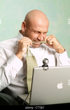 A angry man bites his computer / laptop in the stairs Stock Photo - Alamy