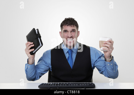 stress out businessman holding a filiofax in one hand and a swash up ...
