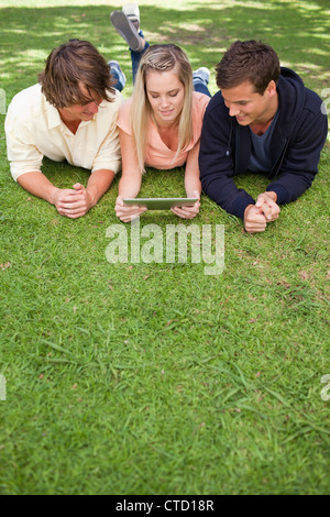 Three young people using a tactile tablet Stock Photo - Alamy