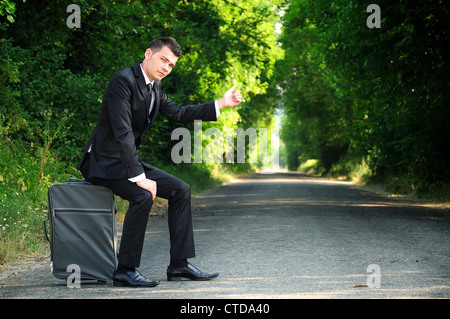 Business man thumb a ride on road Stock Photo - Alamy