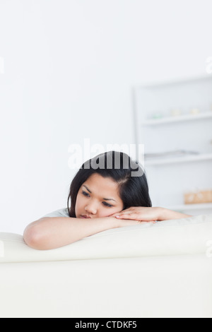 Sad woman resting her face on a sofa Stock Photo - Alamy