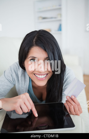 Woman smiling while touching a tactile tablet screen and holding a ...