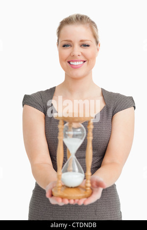 Young happy businesswoman with hourglass showing OK gesture on green ...