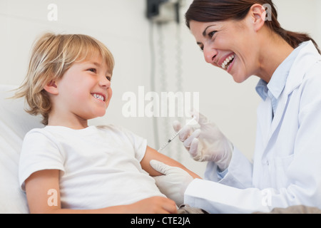 Child receiving an injection by a doctor Stock Photo - Alamy