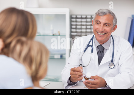 Joyful female doctor writing on clipboard in clinic Stock Photo - Alamy