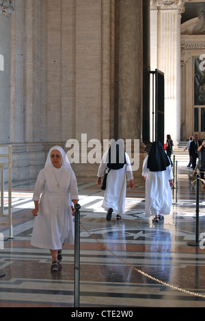 Nuns walk in St. Peter's Square as Pope Francis lies in state inside St ...