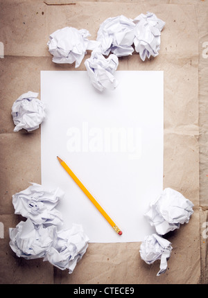 Writing concept - crumpled up paper wads with a sheet of white paper ...