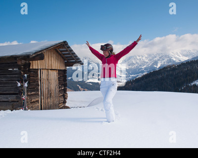 Austria, Maria Alm, Woman at top of mountain blowing snow Stock Photo ...