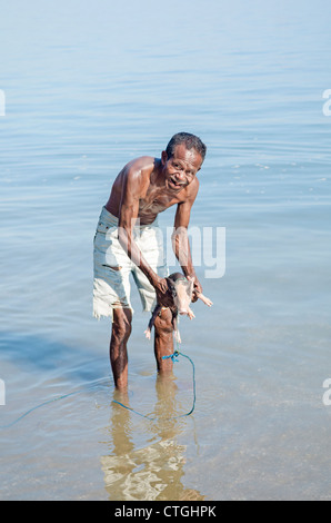Dili, East Timor. Man in traditional dress holding flag of East Timor ...