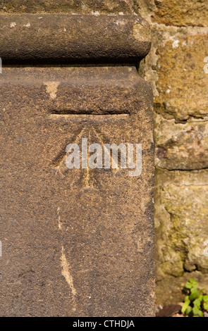 An Ordnance Survey surveyors benchmark carved in to a rock at the side ...