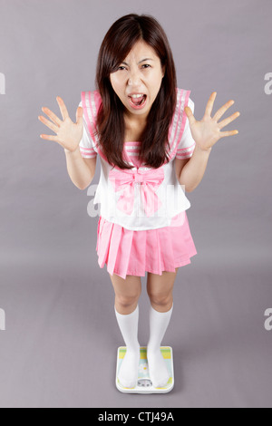 School girl is not happy with weight meter Stock Photo - Alamy