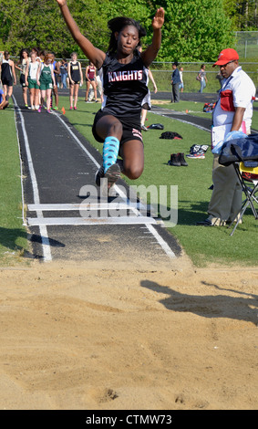 teen doing a high jump during a high school track and field event in ...
