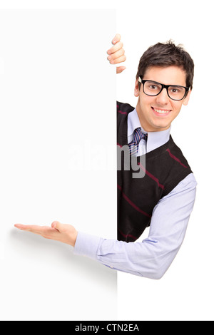 A smiling handsome male posing behind a white panel isolated stock ...