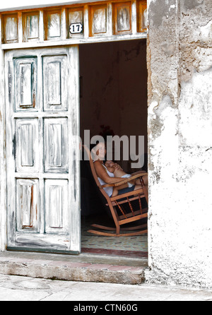 Mother holding and rocking baby sitting on fitball Stock Photo - Alamy