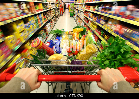 Food hall, full shopping trolley is pushed through a hallway with ...