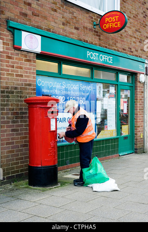 Postman collecting emptying the mail post from a post box outside ...