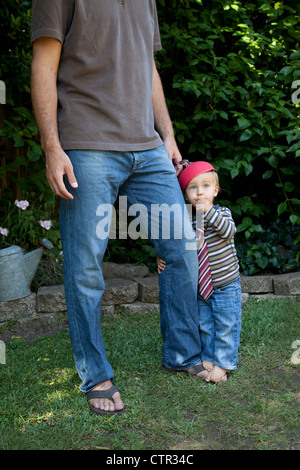 A little boy is hugging his father's pant leg Stock Photo - Alamy